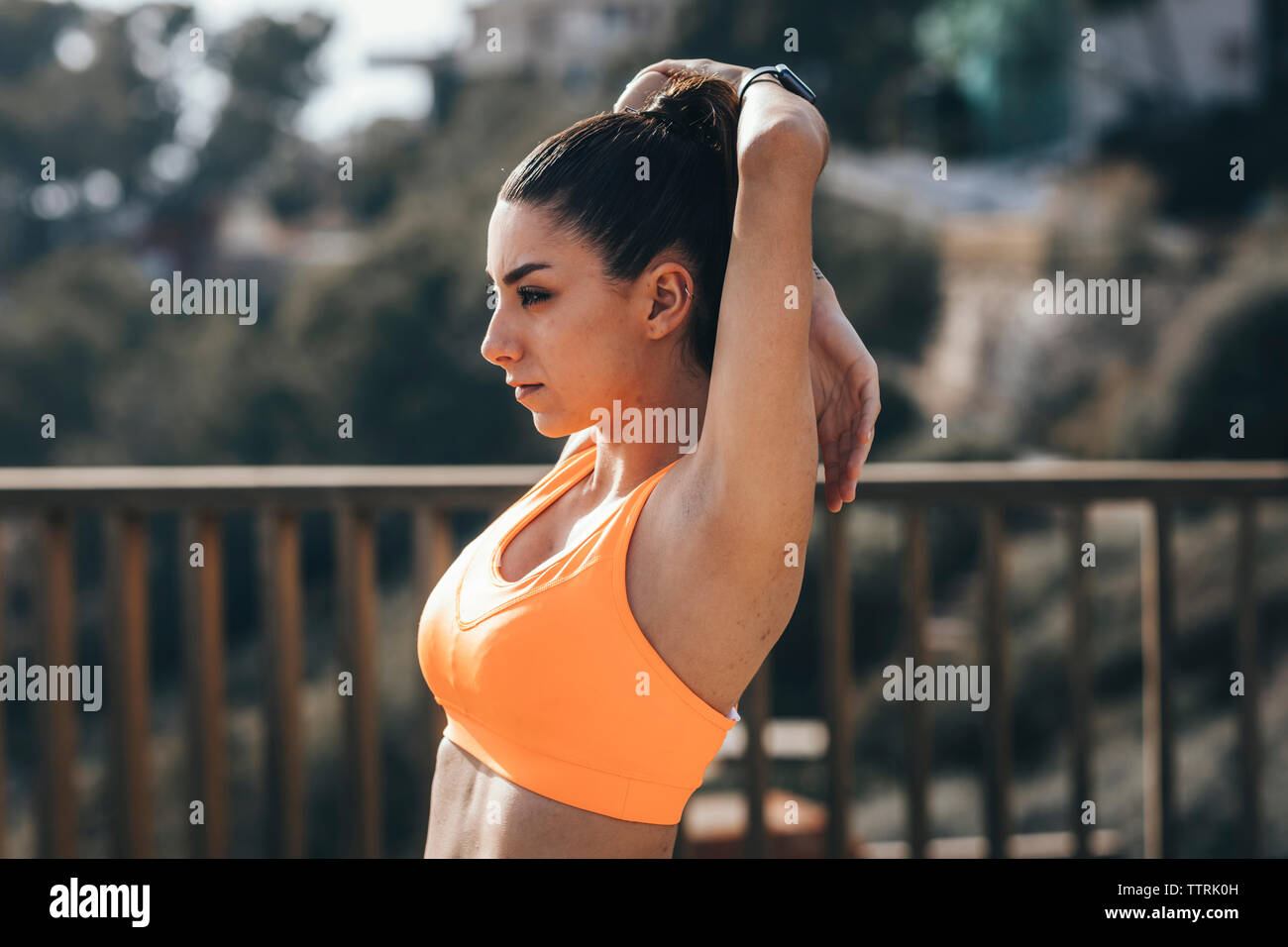 Female athlete exercising while standing against railing Stock Photo ...