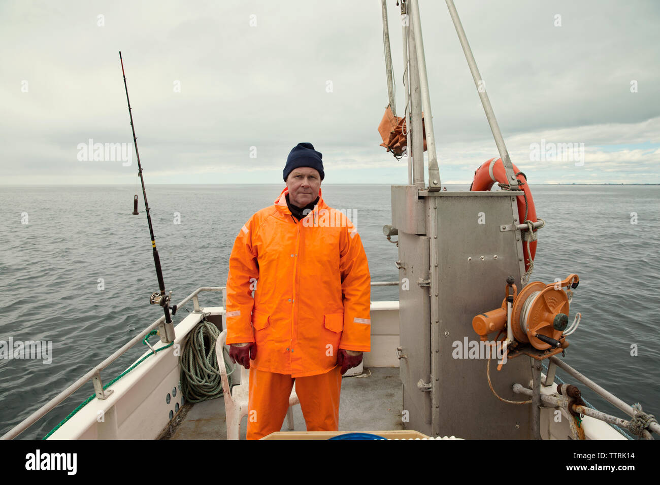 Front view of fisherman standing on fishing boat at sea Stock Photo - Alamy