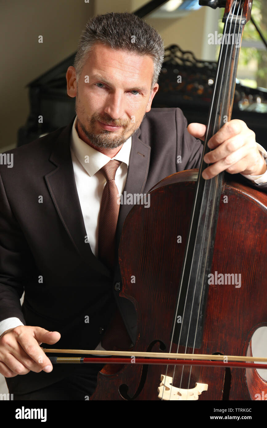 Man playing cello in room Stock Photo - Alamy