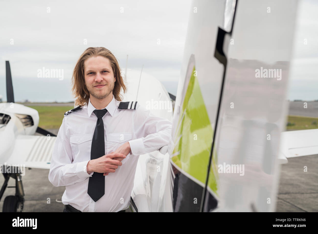 Smiling male pilot standing airplane hi-res stock photography and ...