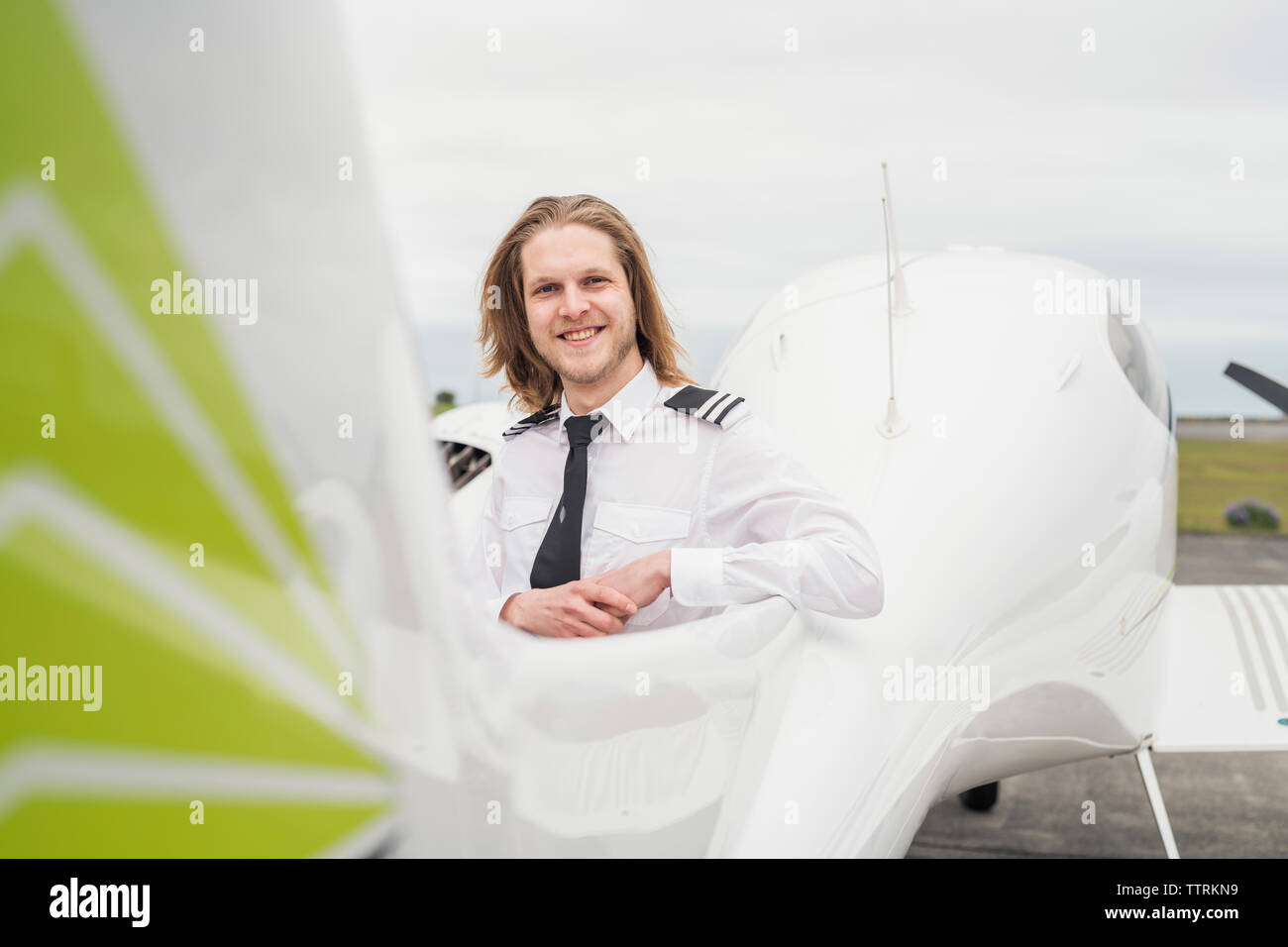 Smiling male pilot standing airplane hi-res stock photography and ...
