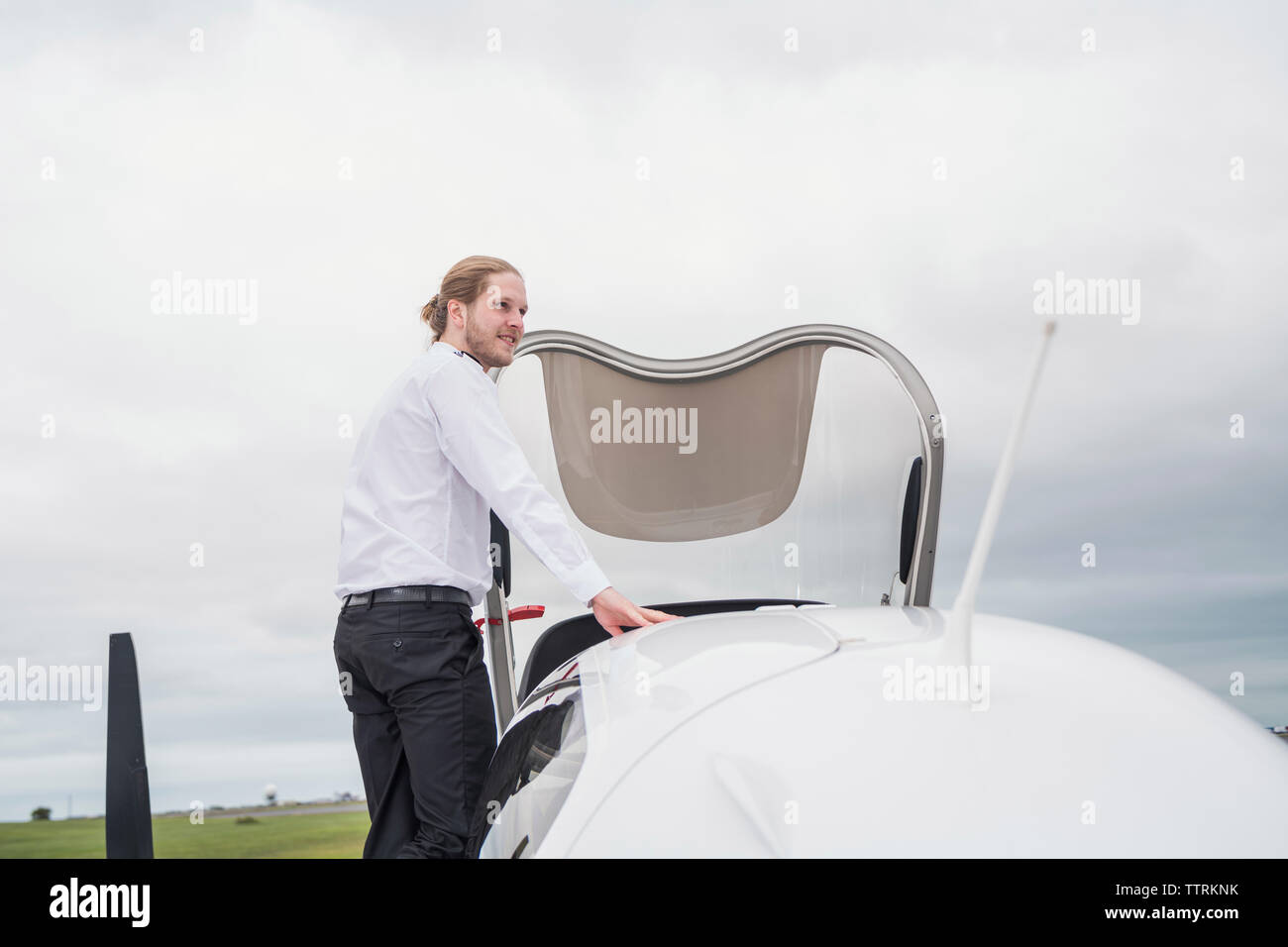 Smiling male pilot standing airplane hi-res stock photography and ...