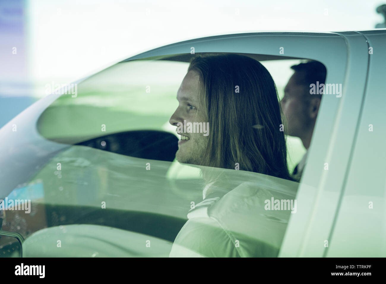 Side view of smiling male trainee flying flight simulator seen through ...