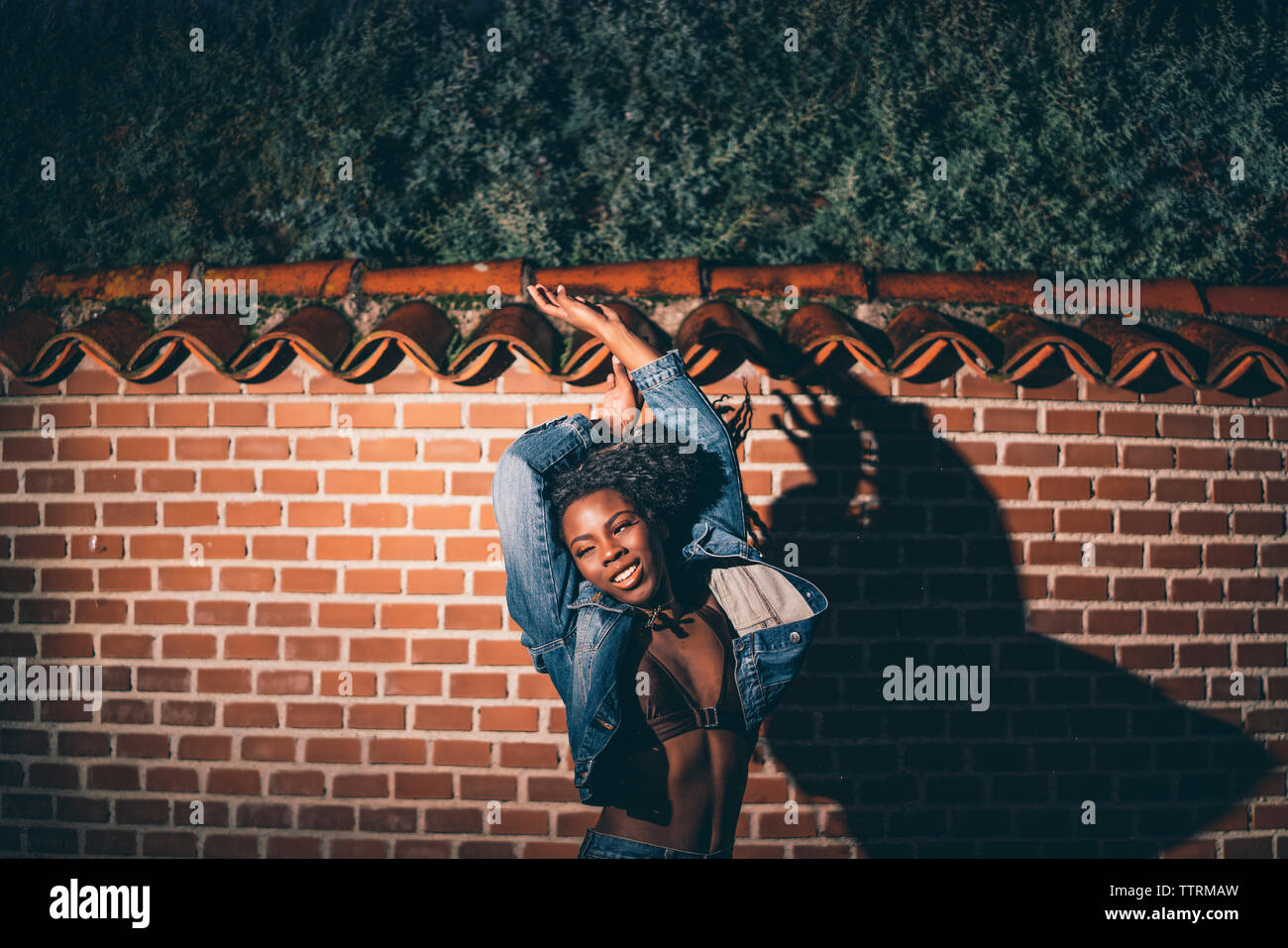 Portrait African woman in a brick wall seen Stock Photo - Alamy
