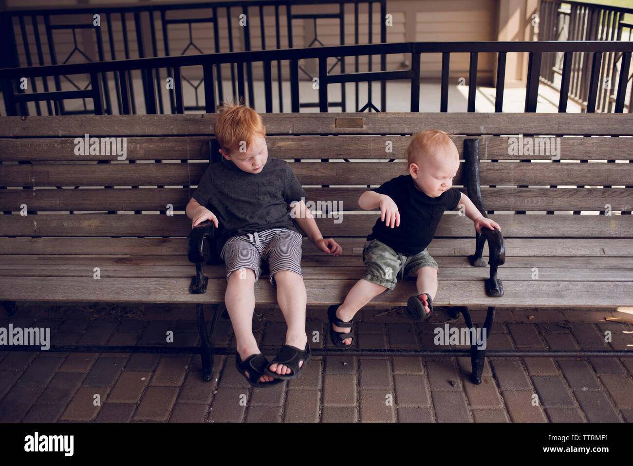Boy sitting on wooden bench hi-res stock photography and images - Alamy