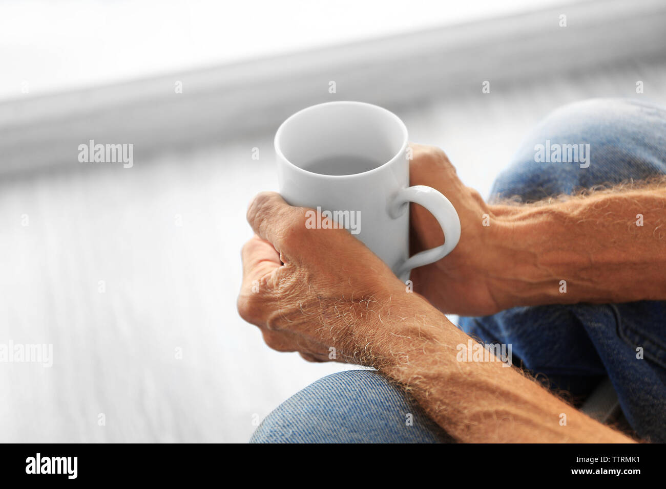 Tired senior man holding coffee hi-res stock photography and images - Alamy