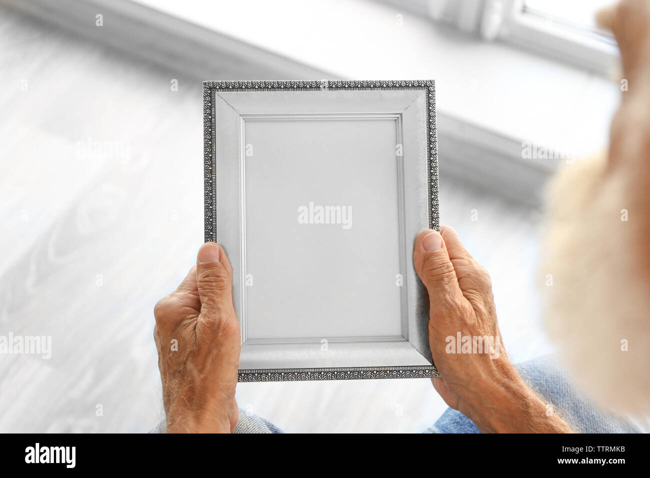 Old man holding photo frame Stock Photo - Alamy