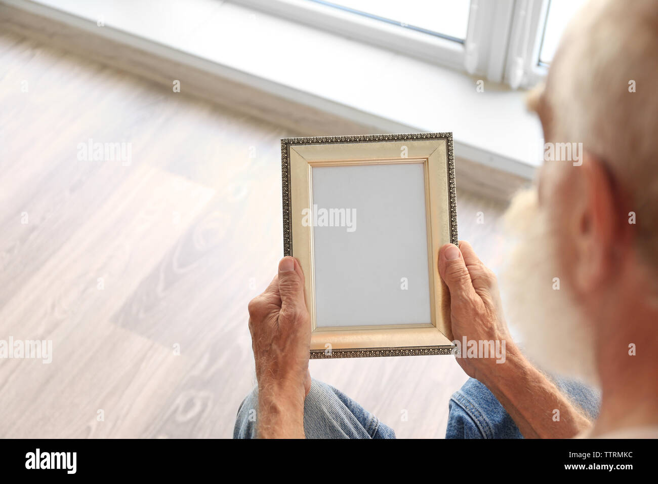 Old man holding photo frame Stock Photo - Alamy