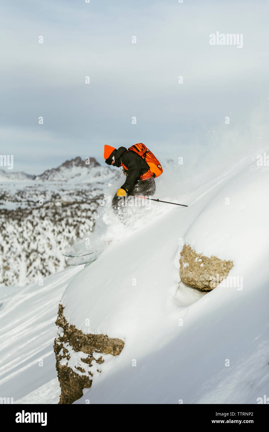 Side view of hiker with backpack skiing on snowcapped mountain Stock ...