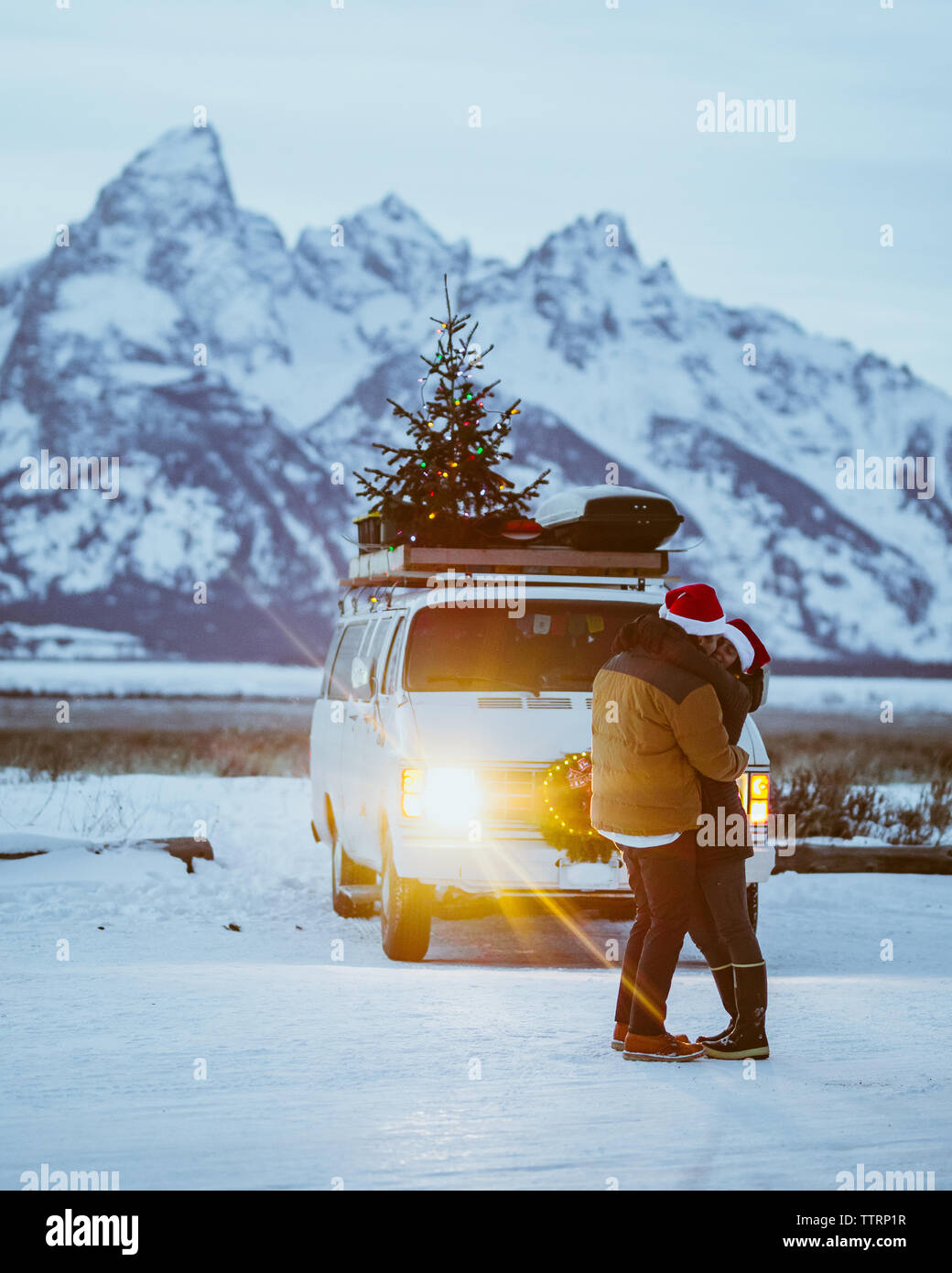 Couple kissing in front of their van life with christmas tree Stock ...