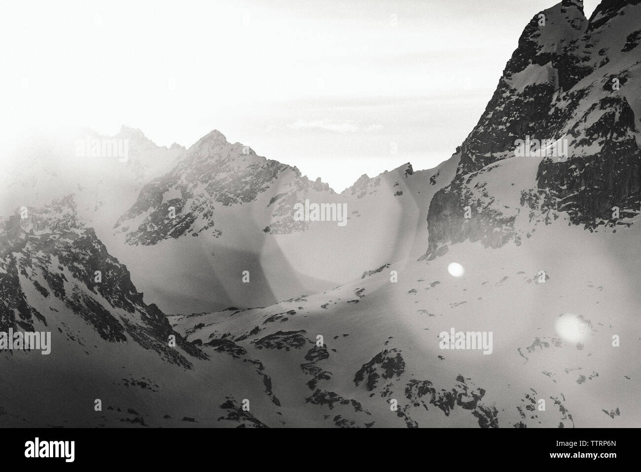 snow cliff and rock in the mountains make a contrasty b&w sunset Stock ...