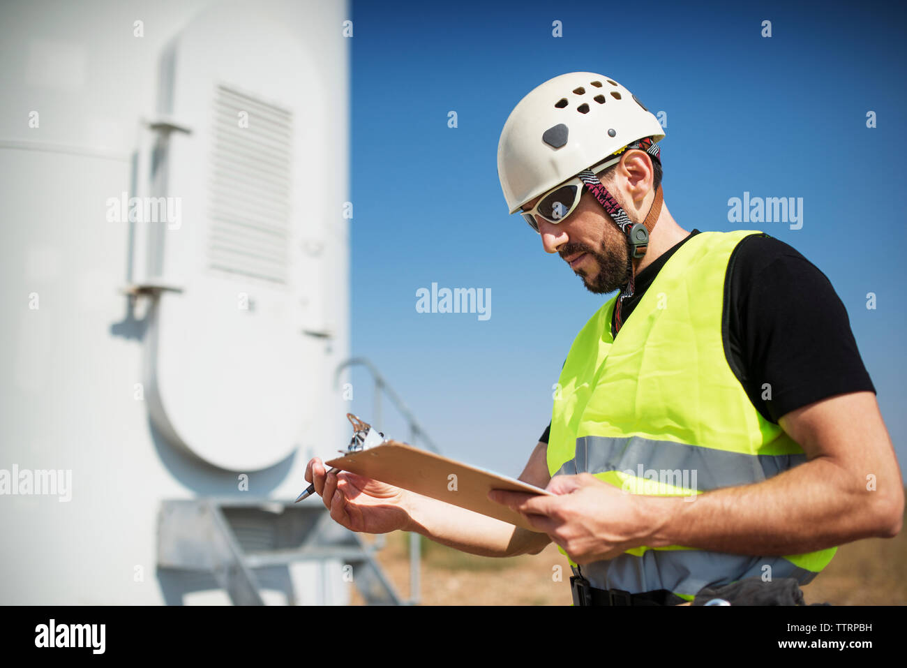 Engineer reading clipboard at construction site Stock Photo - Alamy