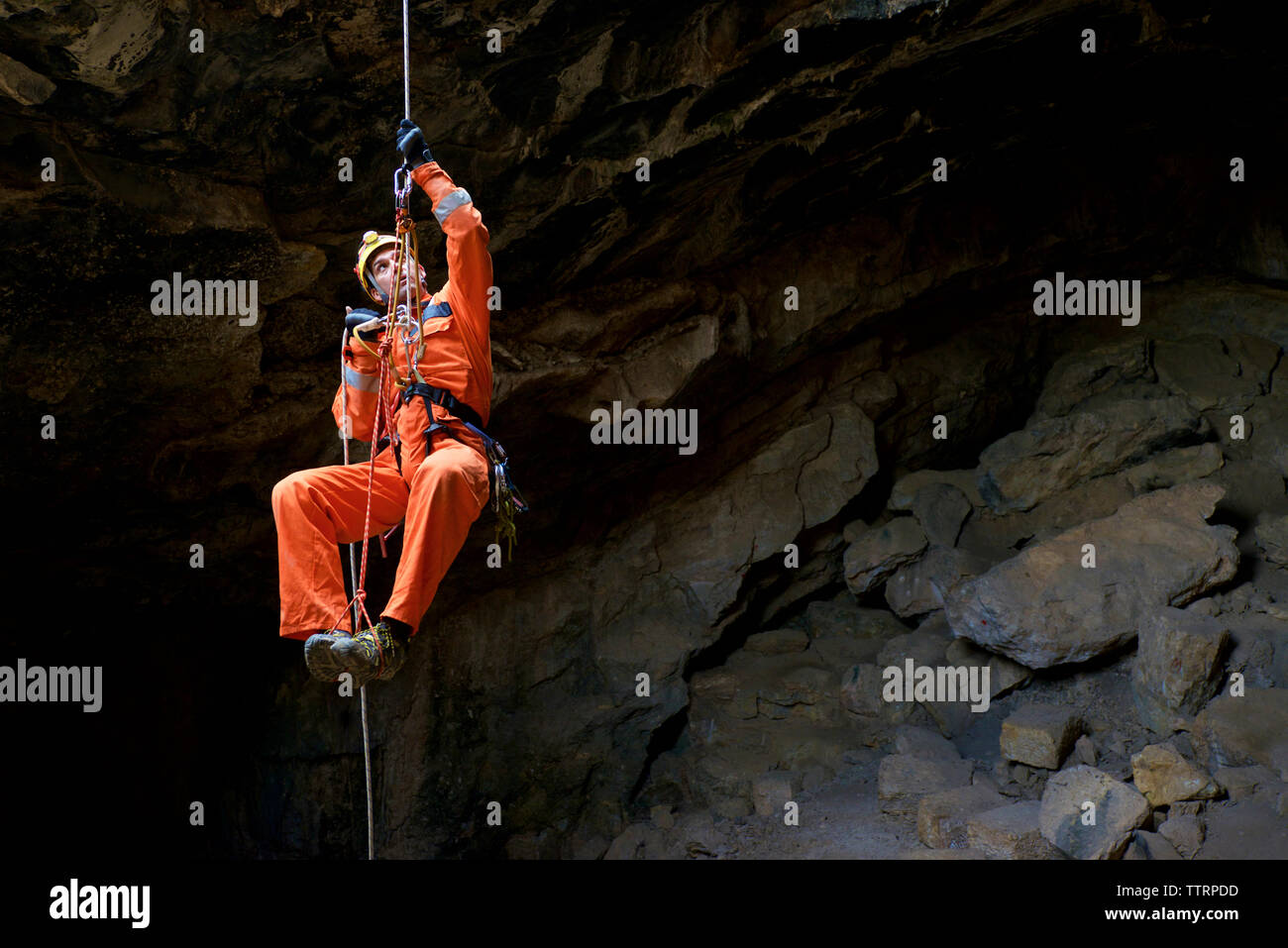 Full length of athlete spelunking in cave Stock Photo - Alamy