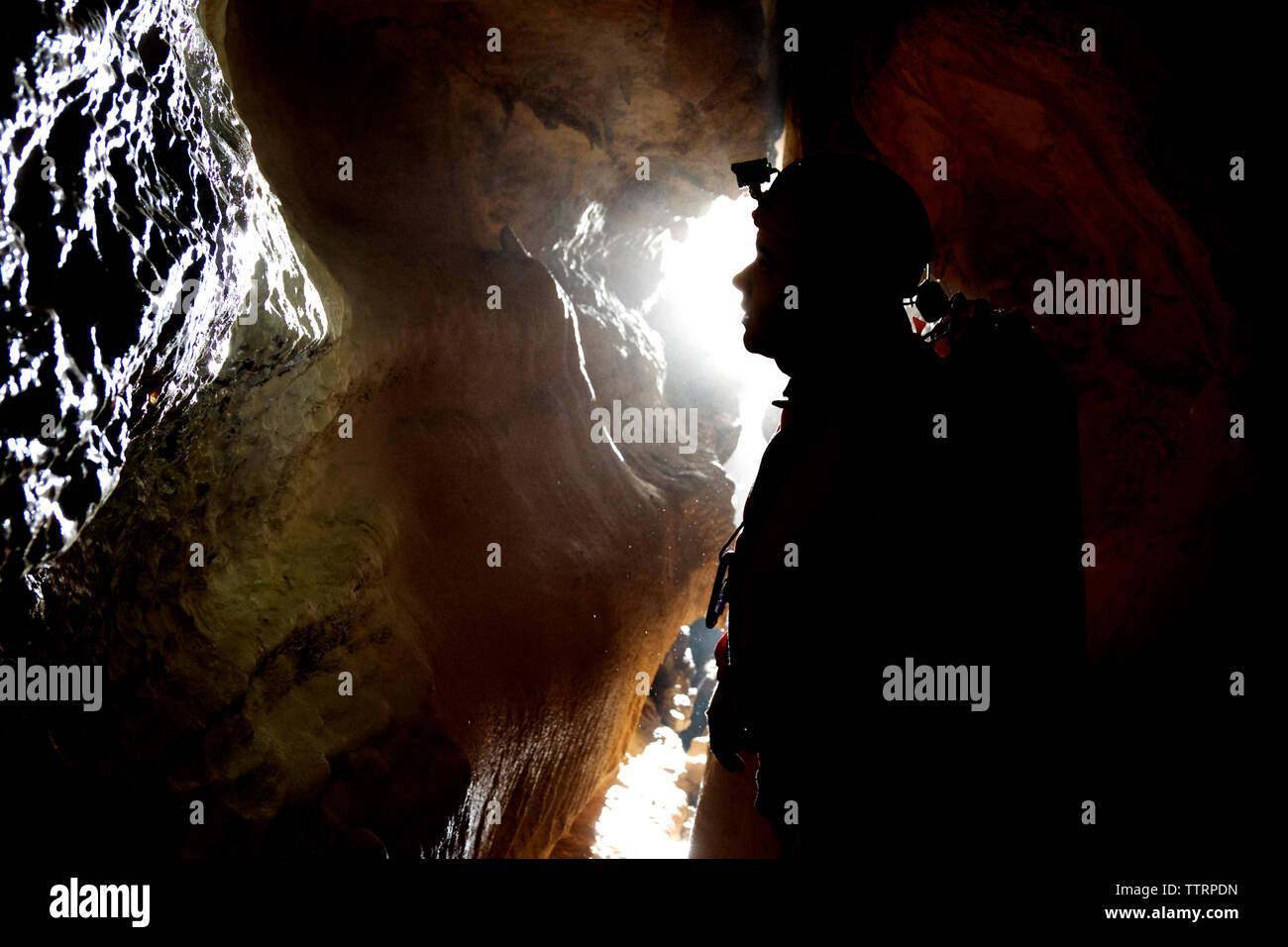 Side view of man working in cave Stock Photo - Alamy