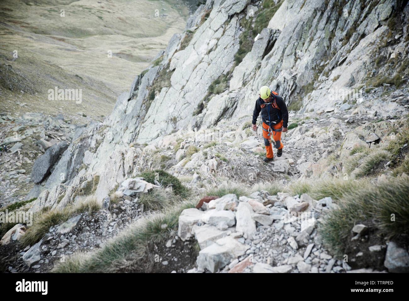 High angle view of hiker walking on rocks during mountain climbing ...