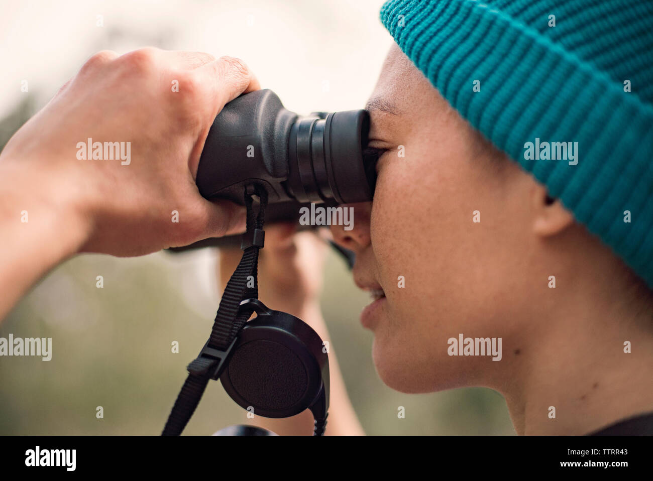 Side view of woman looking through binoculars in forest Stock Photo - Alamy
