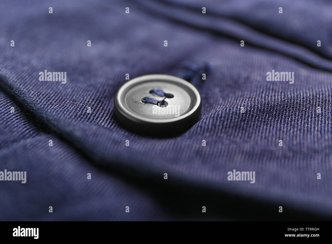 Grey button on clothes, close up Stock Photo - Alamy