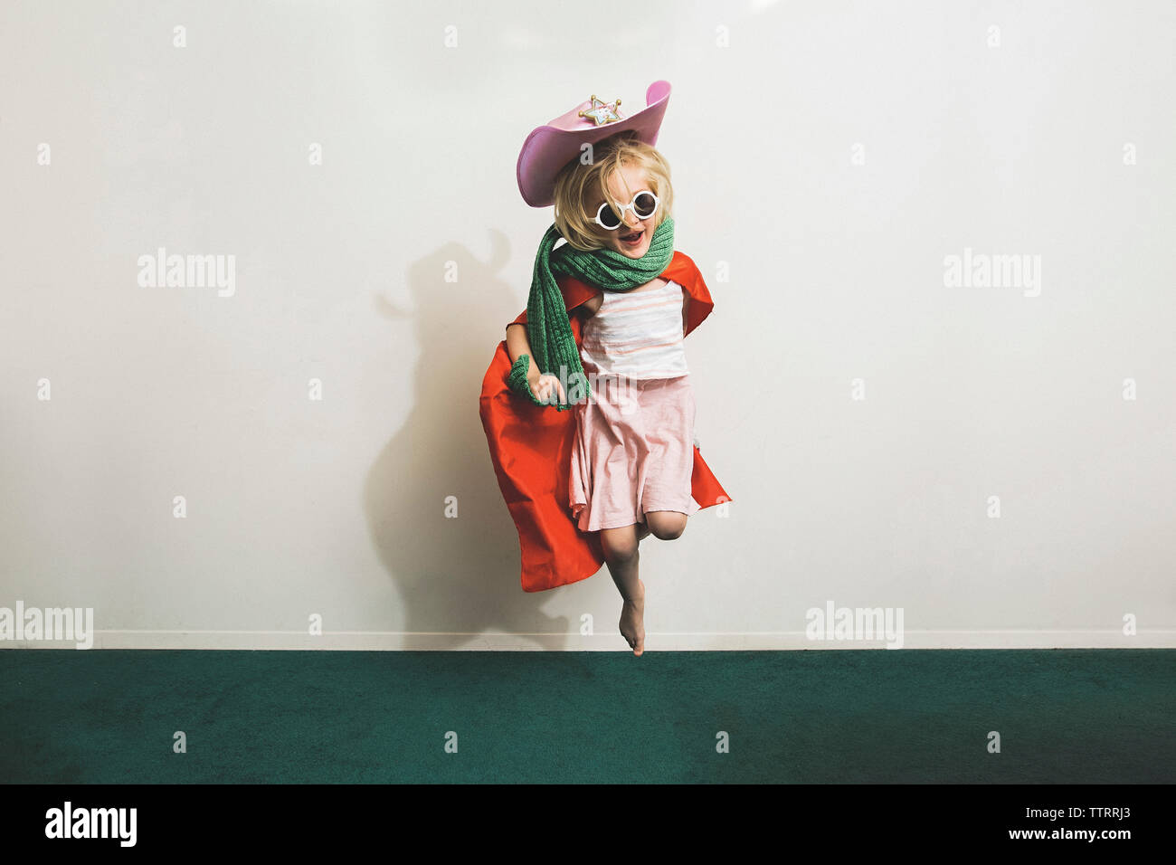 Happy fashionable girl dancing against wall at home Stock Photo - Alamy