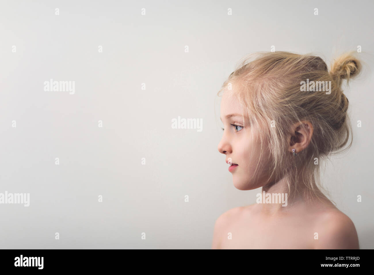 Side view of cute shirtless girl standing against wall at home Stock ...