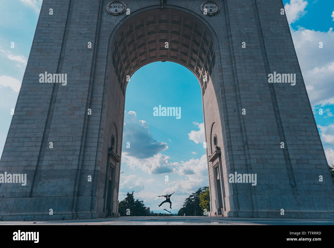 Skateboarder jumping in ancient arch of Victoria Ollie trick skate ...
