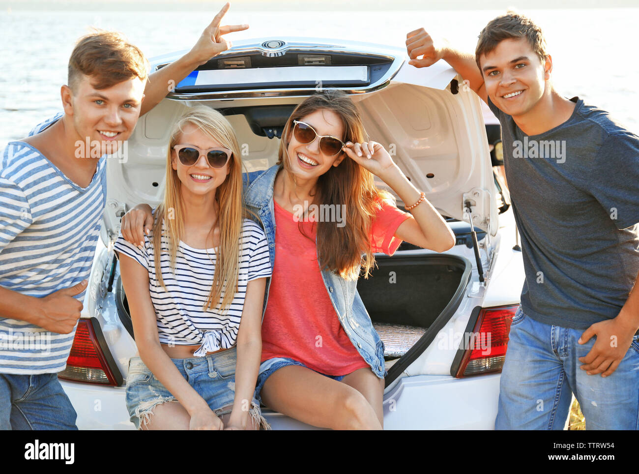Happy friends near car Stock Photo - Alamy