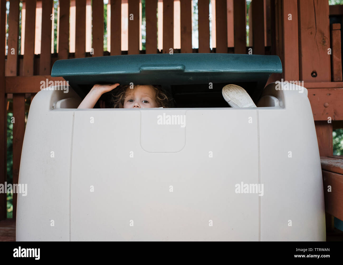 Portrait of cute girl hiding in box at playground Stock Photo - Alamy