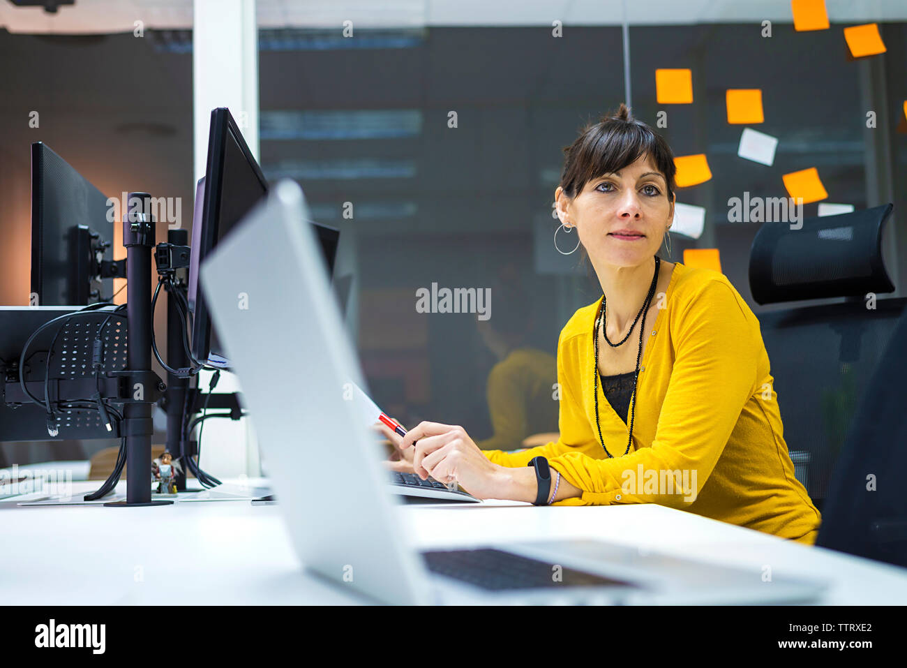 Side view of businesswoman using computer in office looking away Stock ...