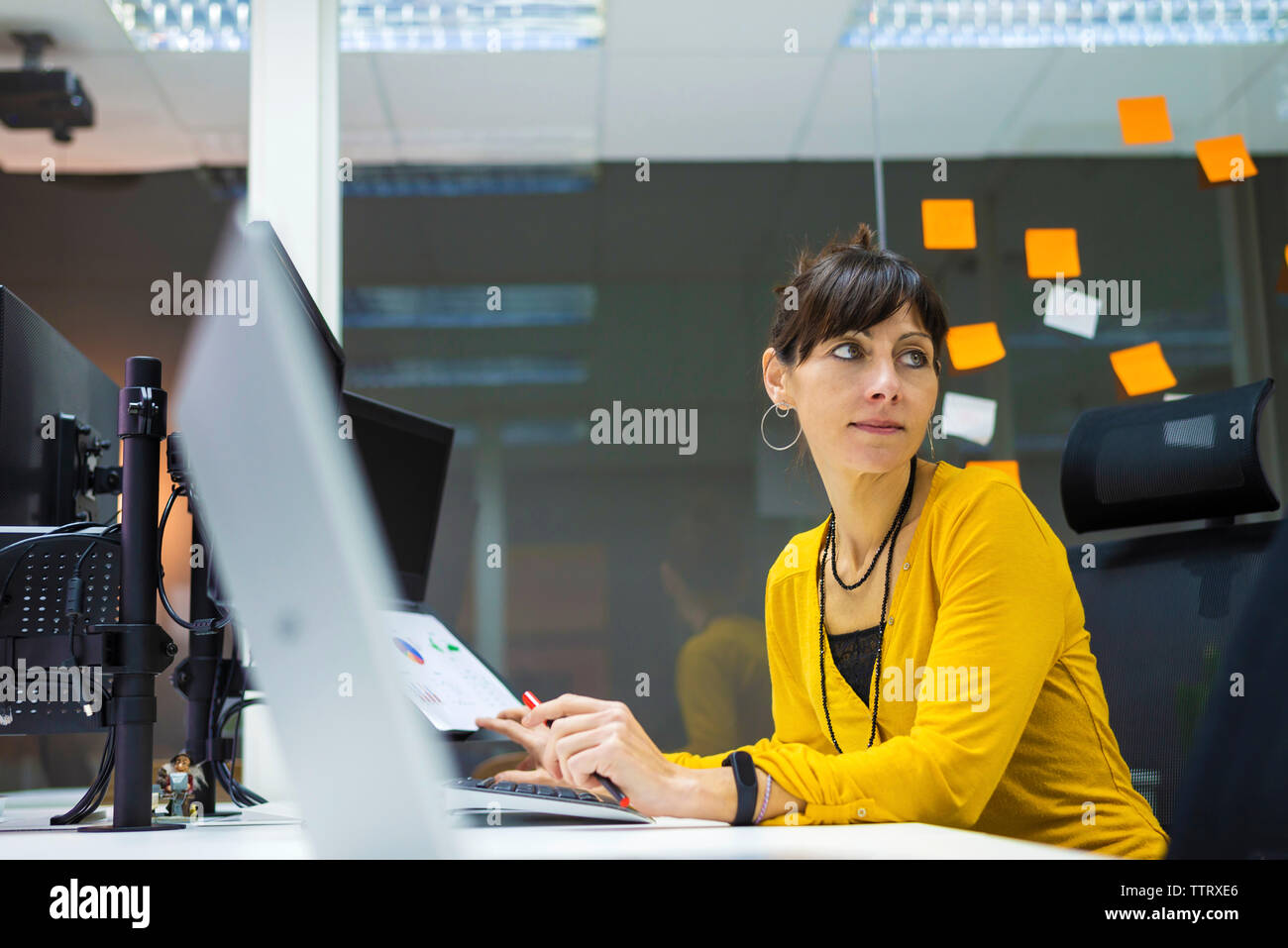 Side view of businesswoman using computer in office looking away Stock ...