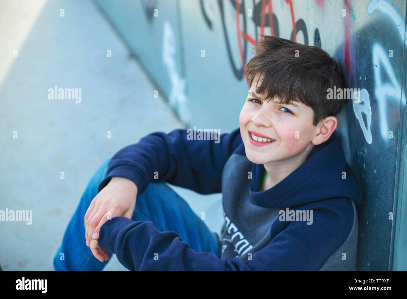 Above view of young teen with casual clothes while sitting on ground ...
