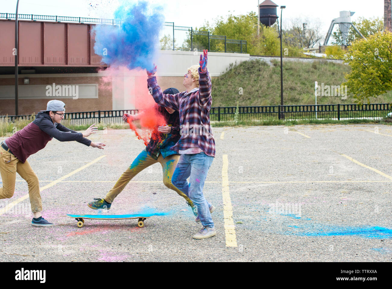 Friends playing with powder paints at park Stock Photo - Alamy