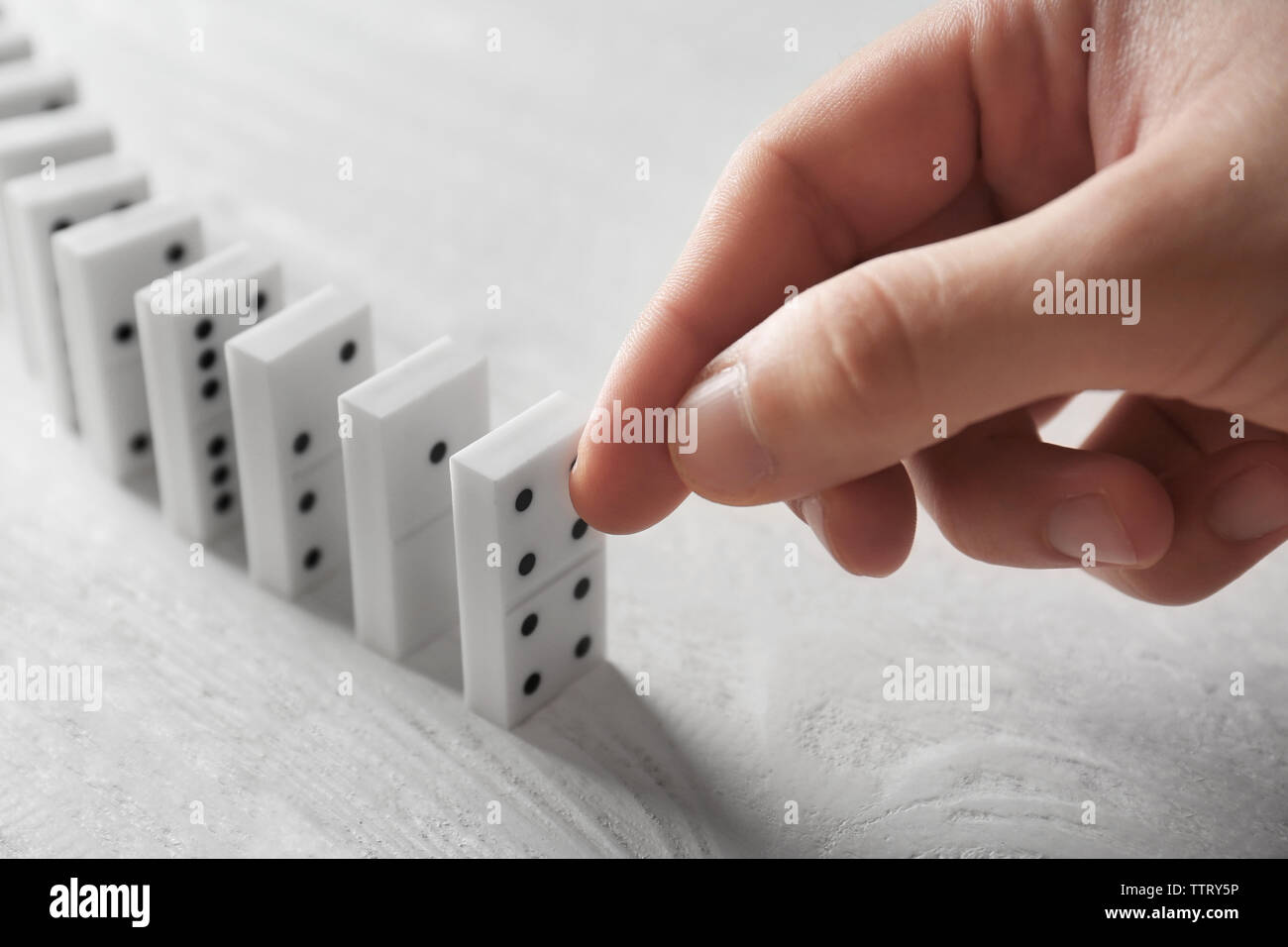 Hand pushing dominoes hi-res stock photography and images - Alamy