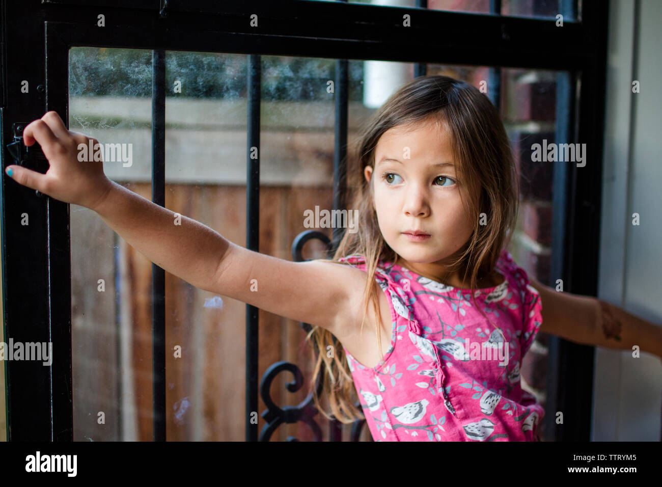 a little girl stands at an open doorway looking off into the distance ... a little girl stands at an open doorway looking off into the distance ...