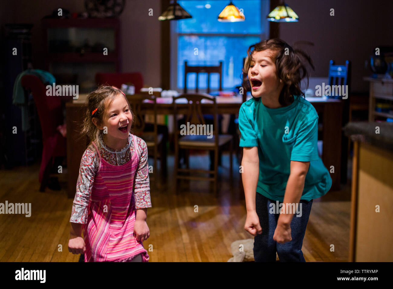 Siblings laughing and singing together at home Stock Photo - Alamy