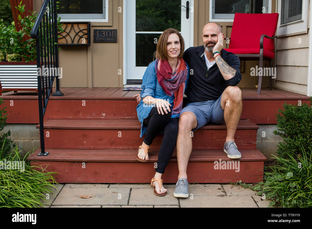 a happy couple sit together on their front stoop Stock Photo - Alamy