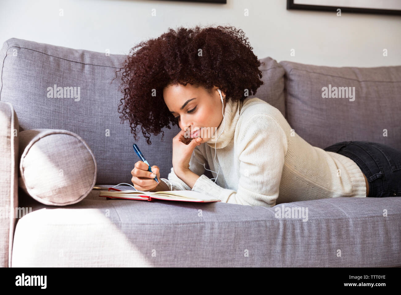 Woman writing book sofa hi-res stock photography and images - Alamy