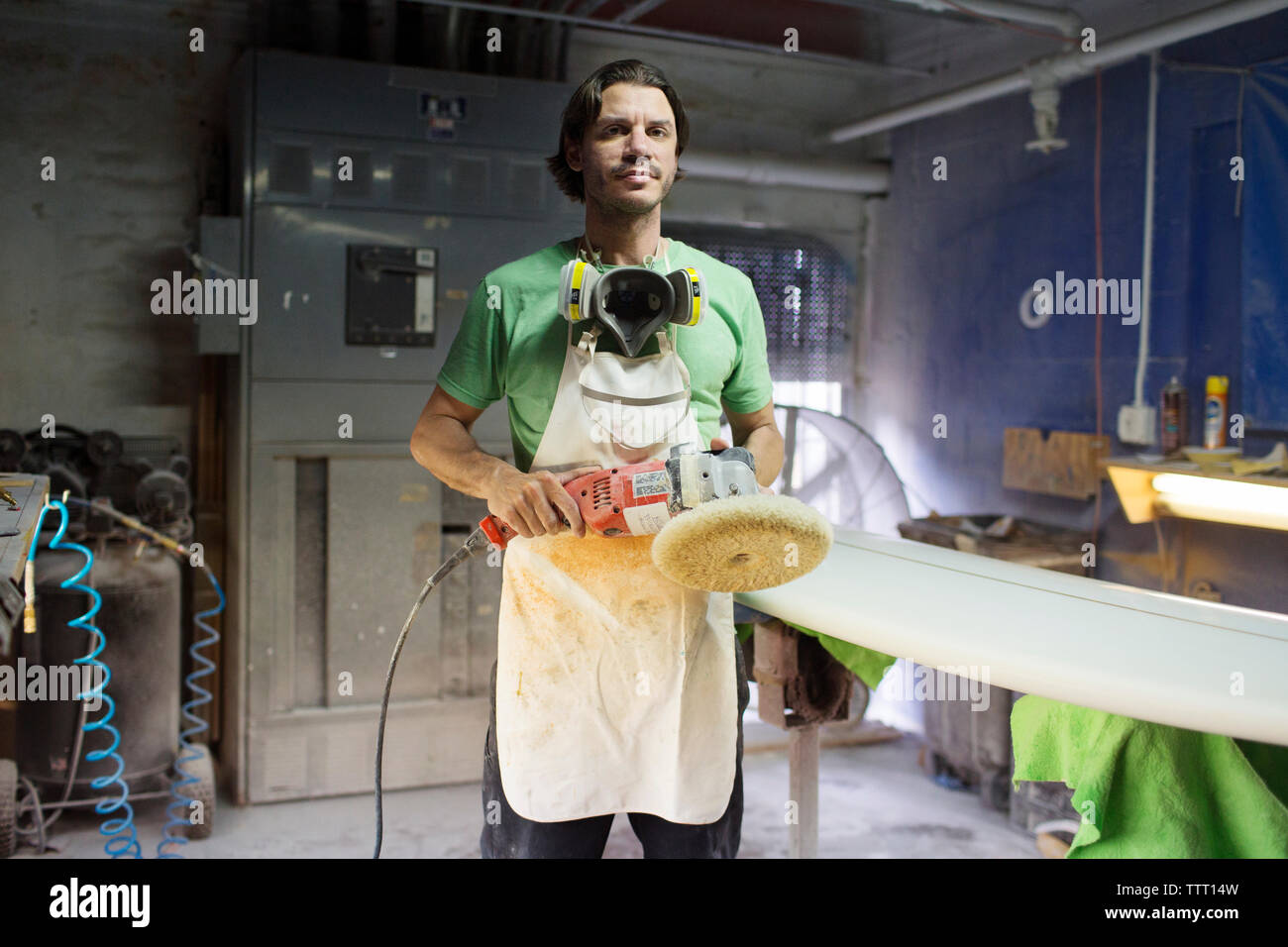 Portrait of male worker holding sander while standing in workshop Stock ...