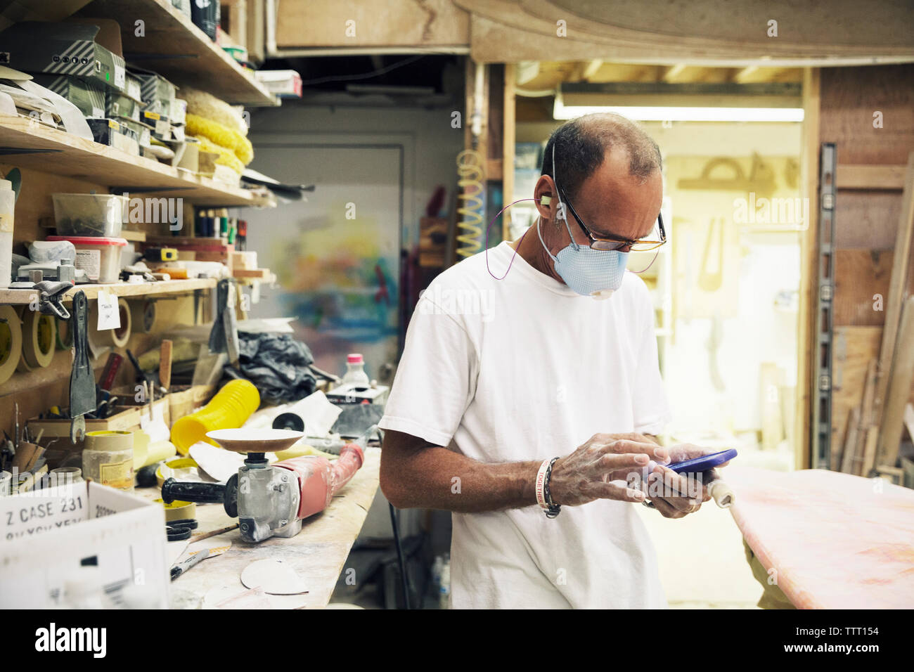Craftsman using mobile phone in workshop Stock Photo - Alamy