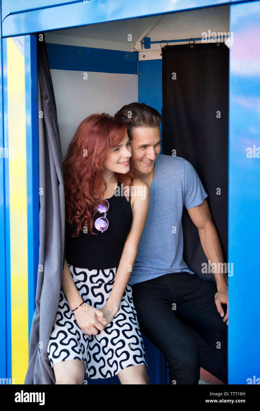 Young couple sitting in photo booth smiling Stock Photo - Alamy