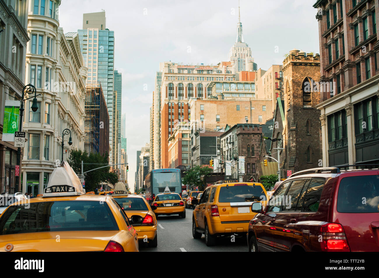 Cars on city street amidst buildings Stock Photo - Alamy