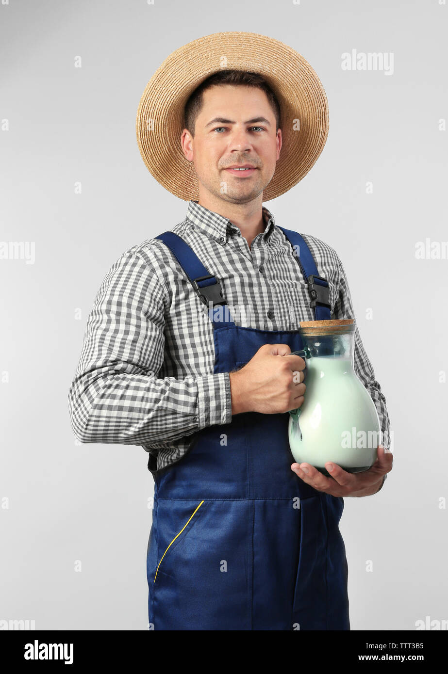 Milkman with glass jar on light background Stock Photo - Alamy