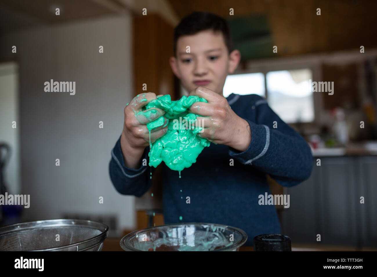 Tween boy making funny face as he makes homemade slime Stock Photo - Alamy