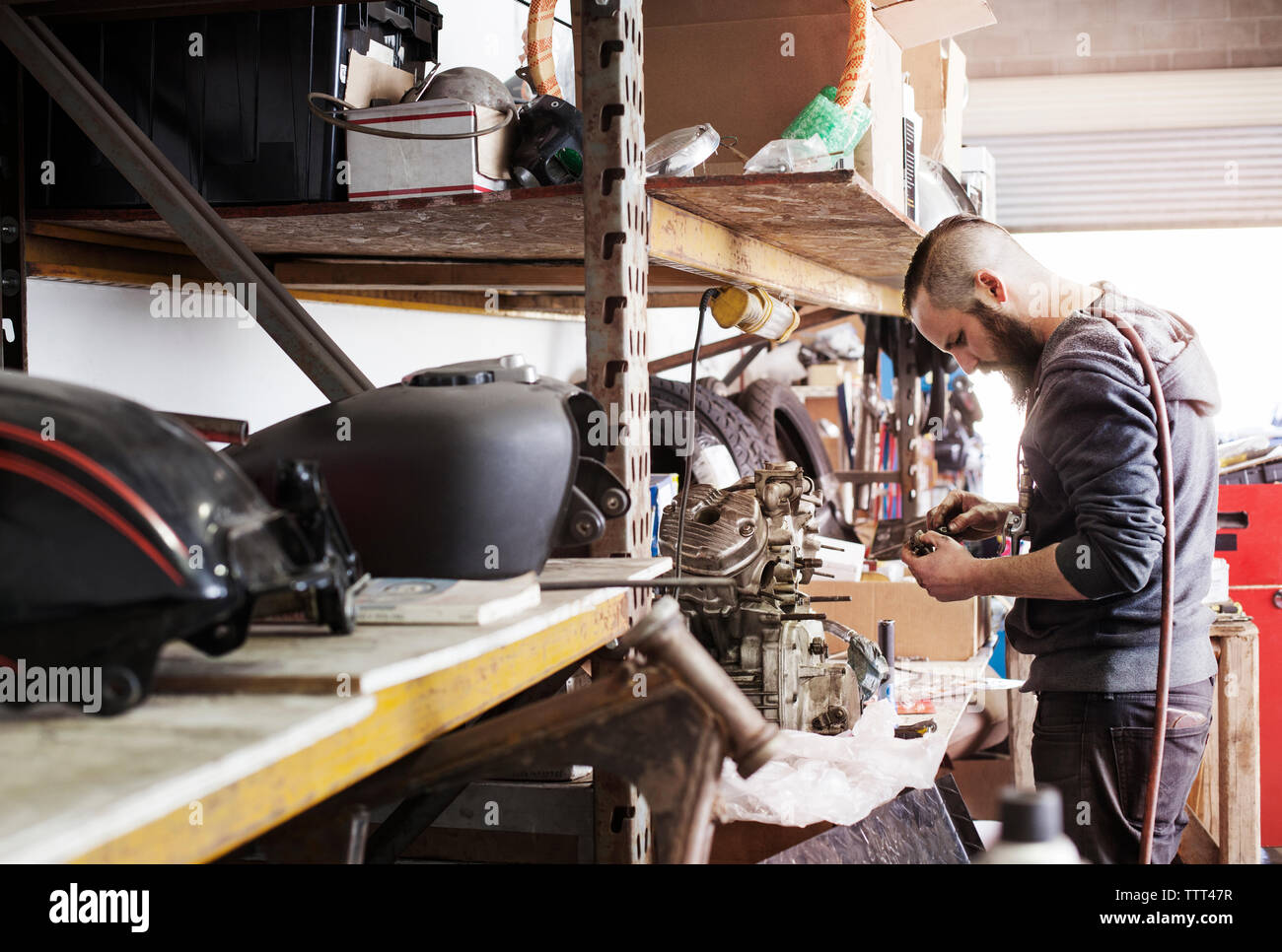 Side view of serious man working at auto repair shop Stock Photo - Alamy