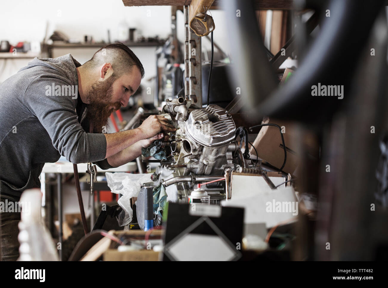 Serious mechanic working on motorcycle engine at auto repair shop Stock ...