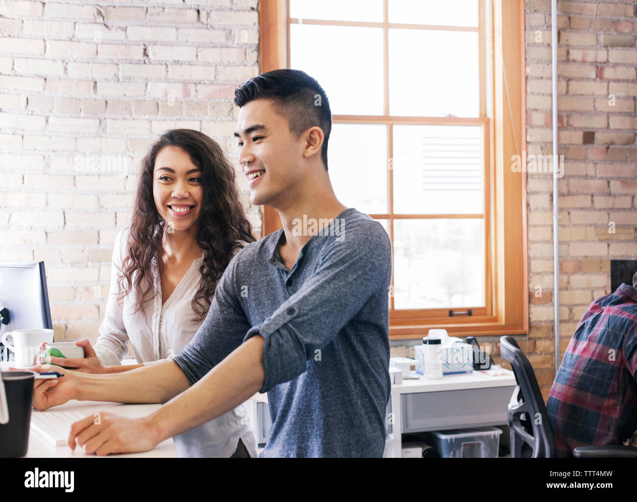 Smiling business people looking at desktop computer while working in ...