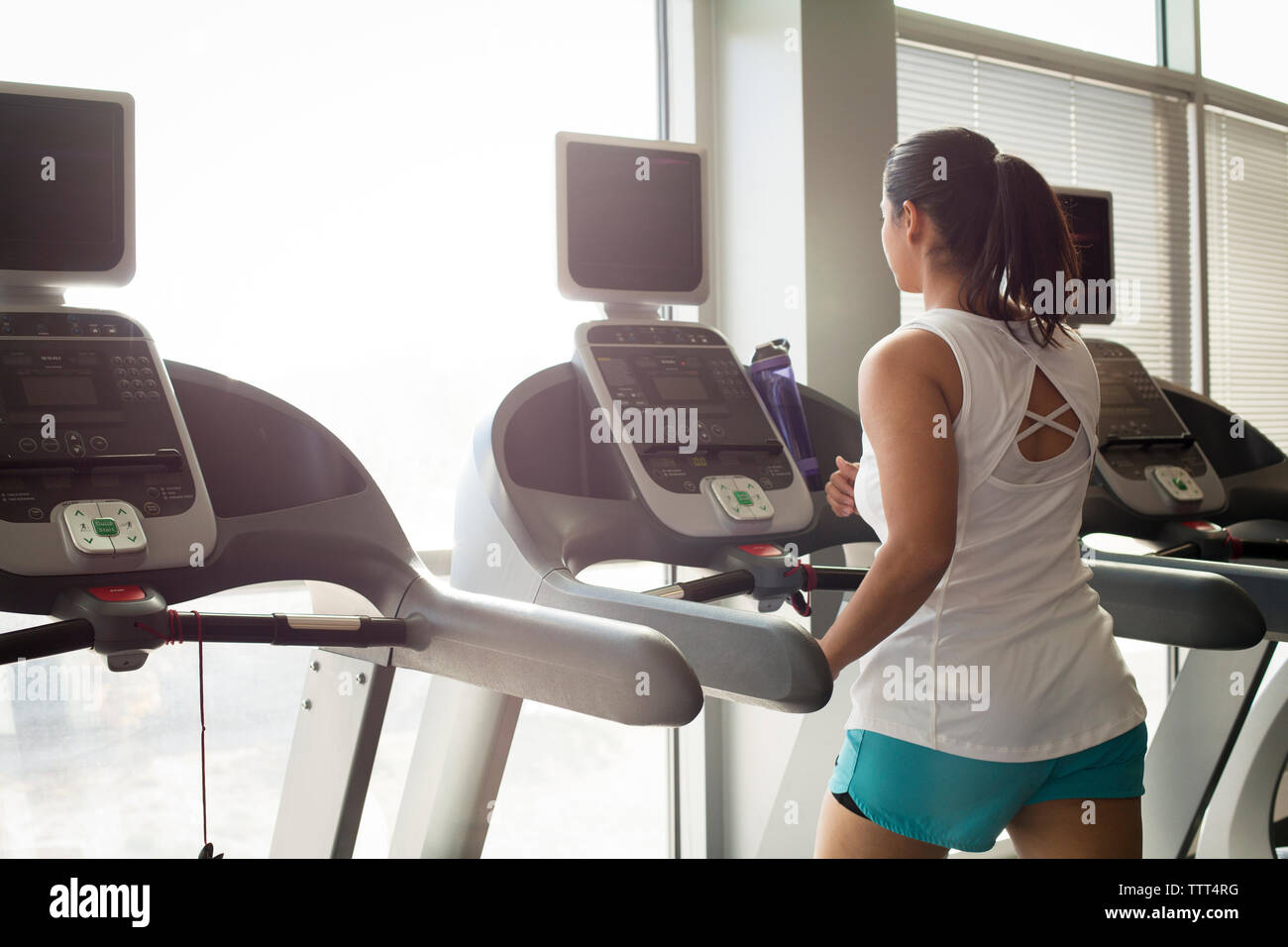 Rear view of woman on treadmill in gym Stock Photo - Alamy