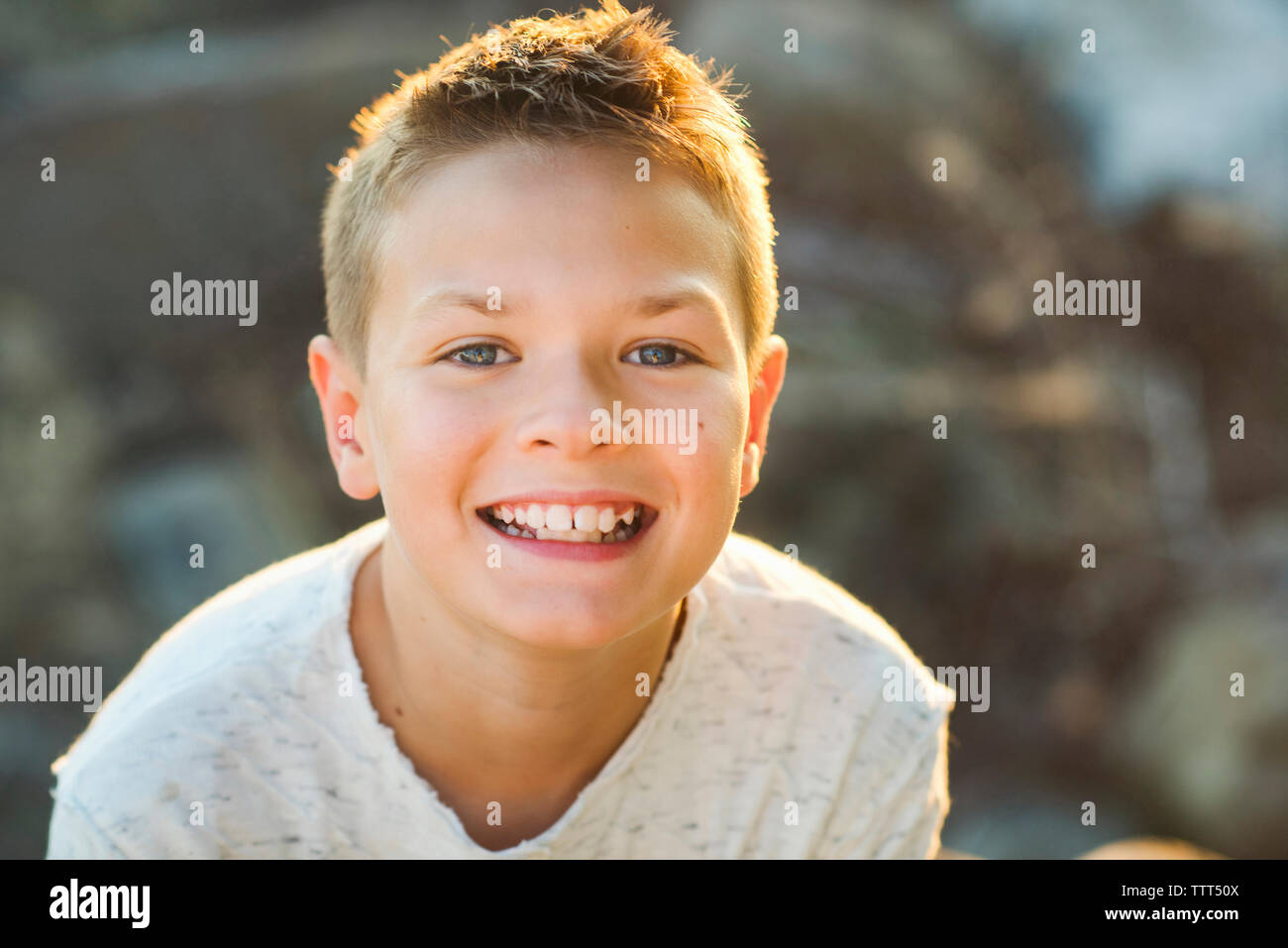 Close-up portrait of cute happy boy sitting outdoors Stock Photo - Alamy