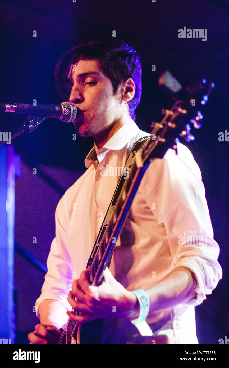 Confident male singer singing and playing guitar in nightclub Stock ...