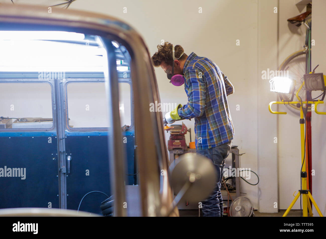 Side view of engineer polishing van with angle grinder in factory Stock ...