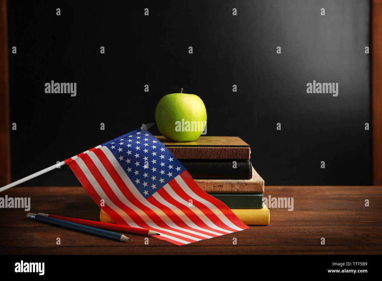 American flag with books and apple on chalk board background Stock ...