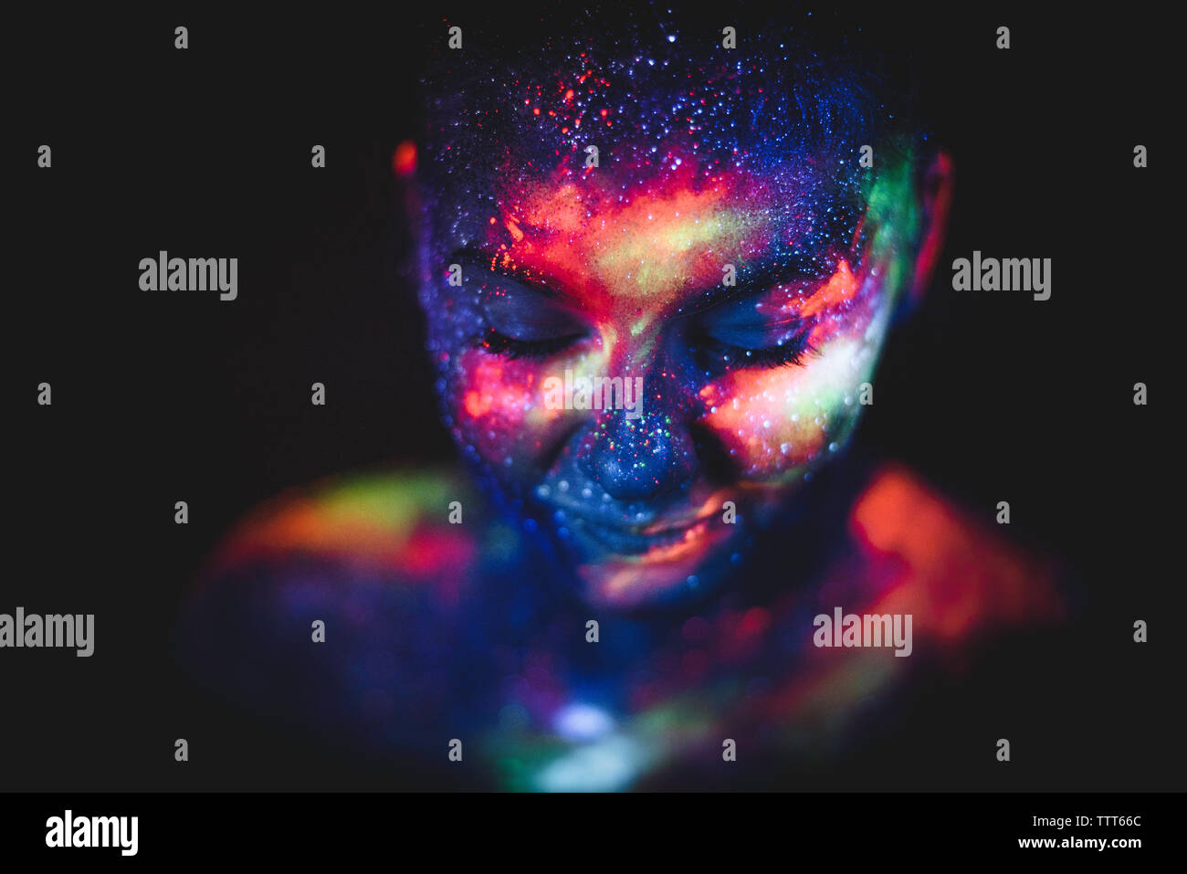 Conceptual shot of light and shine fluorescent colors young girl's face ...